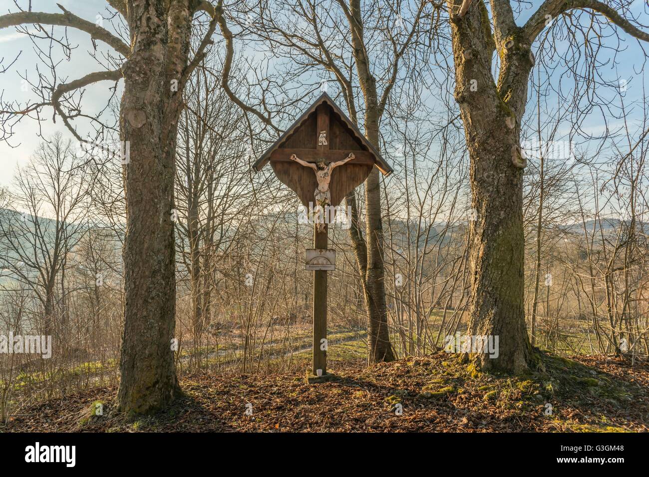 Old weathered wayside cross in the middle of two trees in bavarian ...
