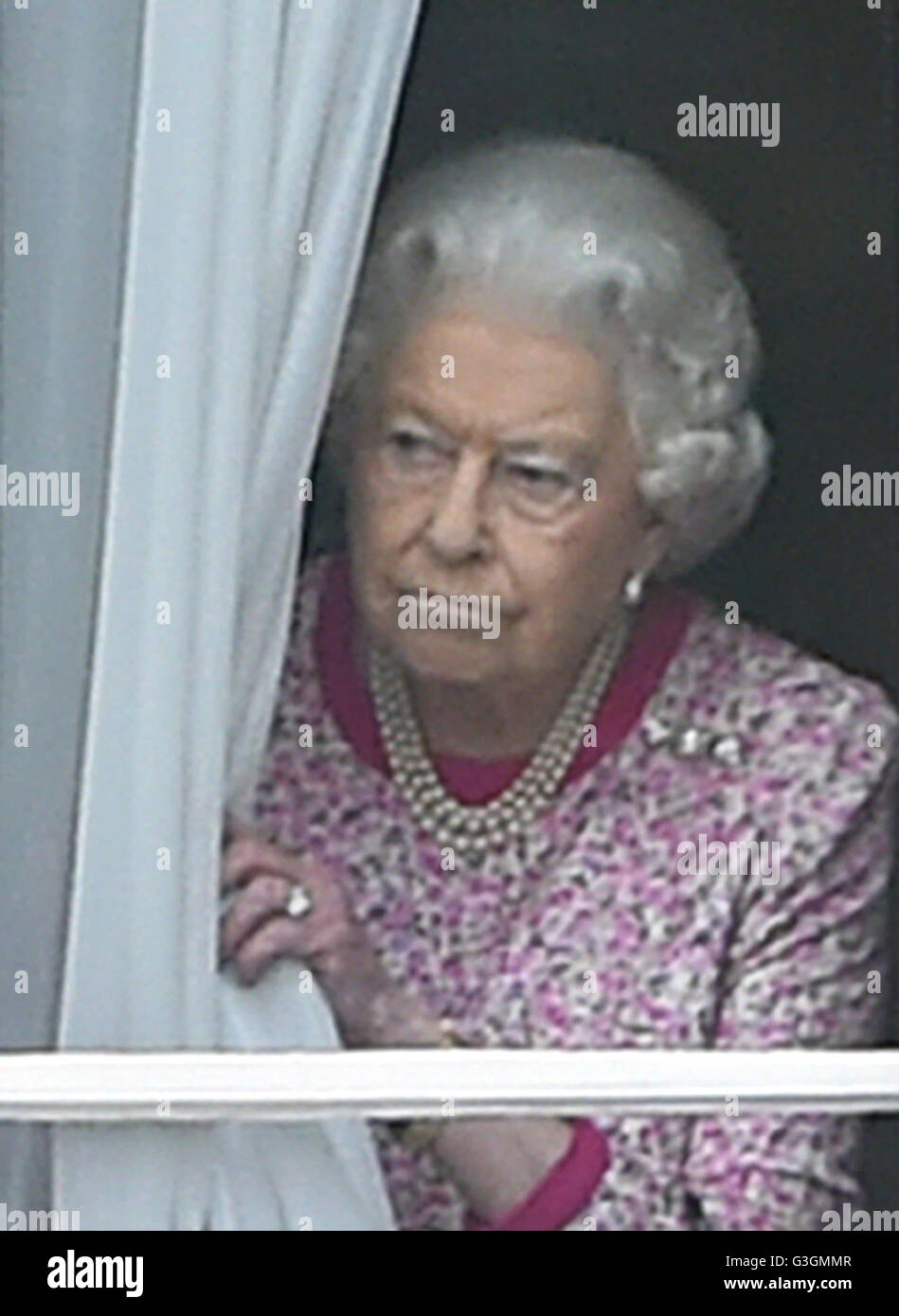 Queen Elizabeth II looks out from the window at Buckingham Palace ...