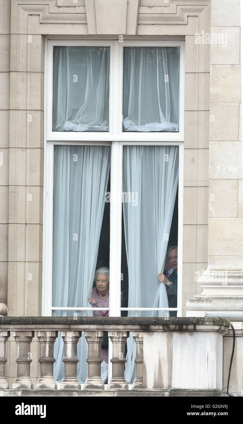 Queen Elizabeth II looks out from the window at Buckingham Palace ...
