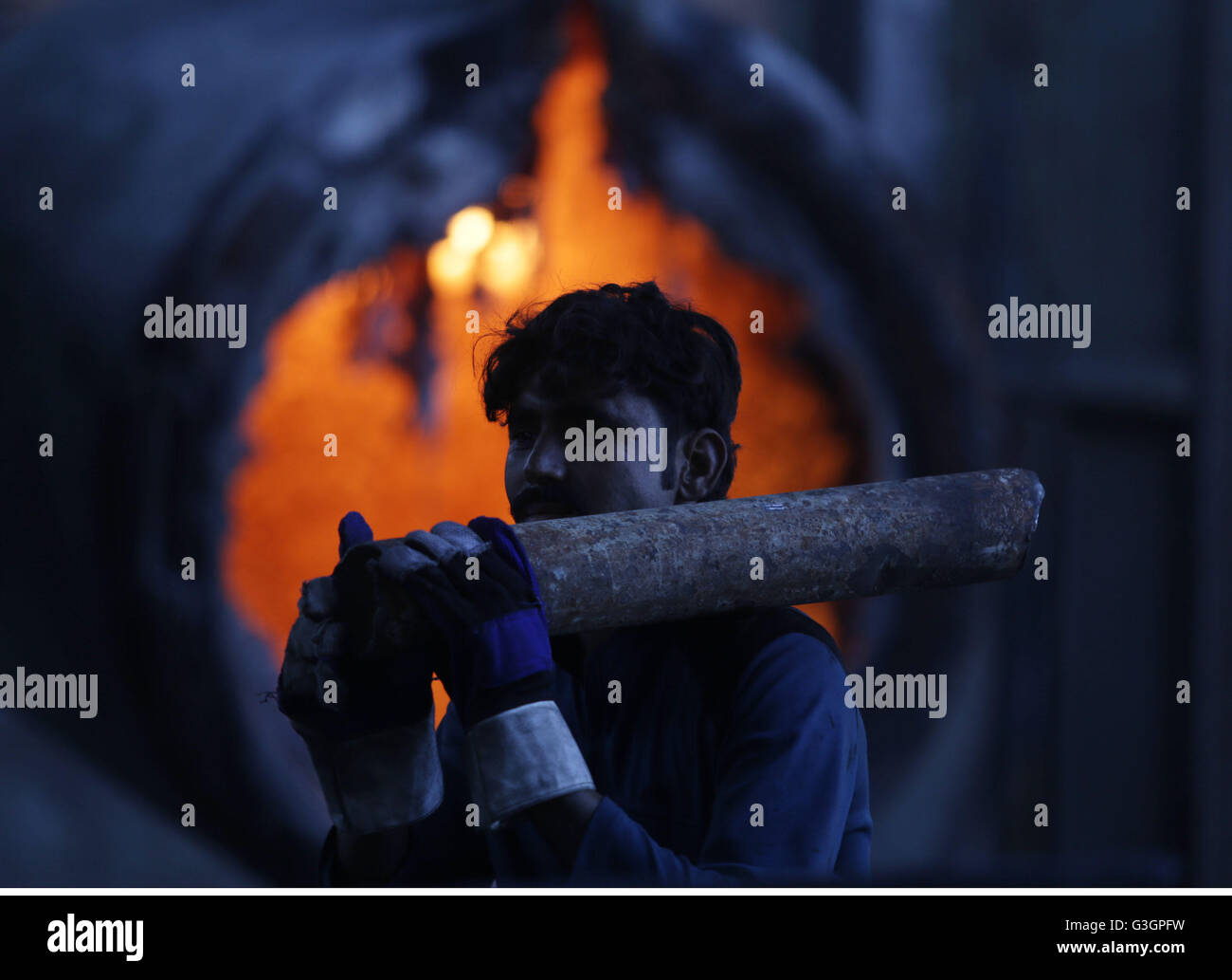 Pakistani blacksmiths work at an iron molding factory in an industrial ...