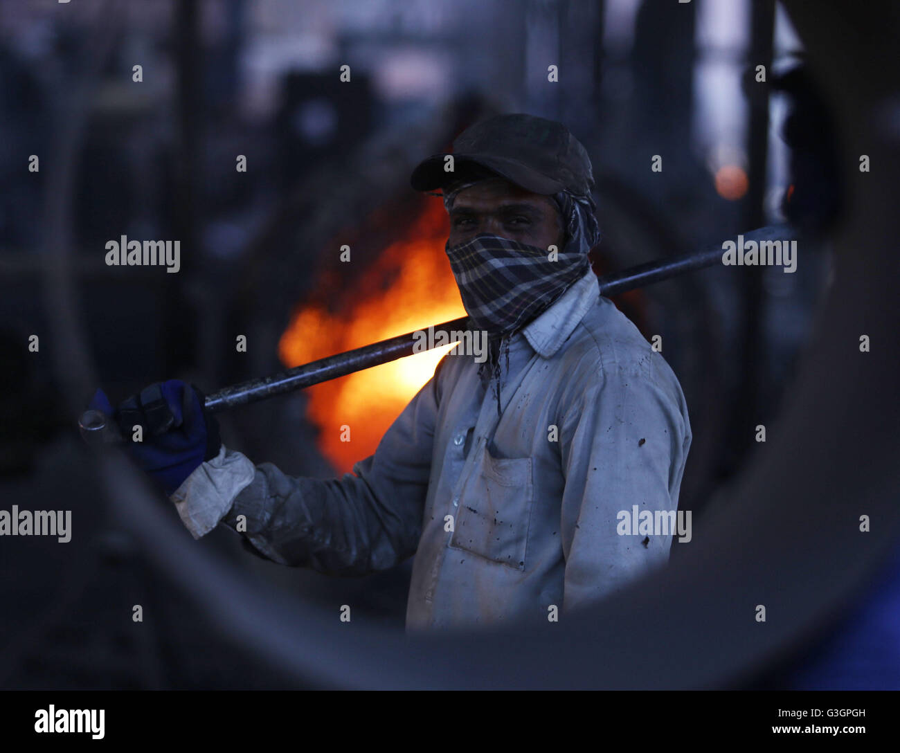 Pakistani blacksmiths work at an iron molding factory in an industrial ...