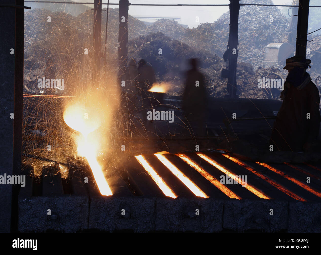 Pakistani blacksmiths work at an iron molding factory in an industrial ...