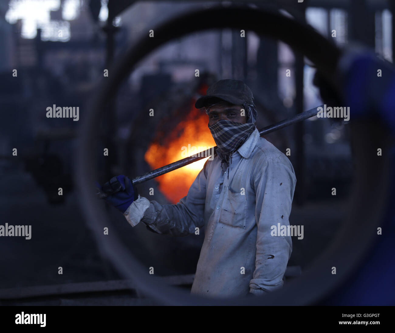 Pakistani blacksmiths work at an iron molding factory in an industrial ...