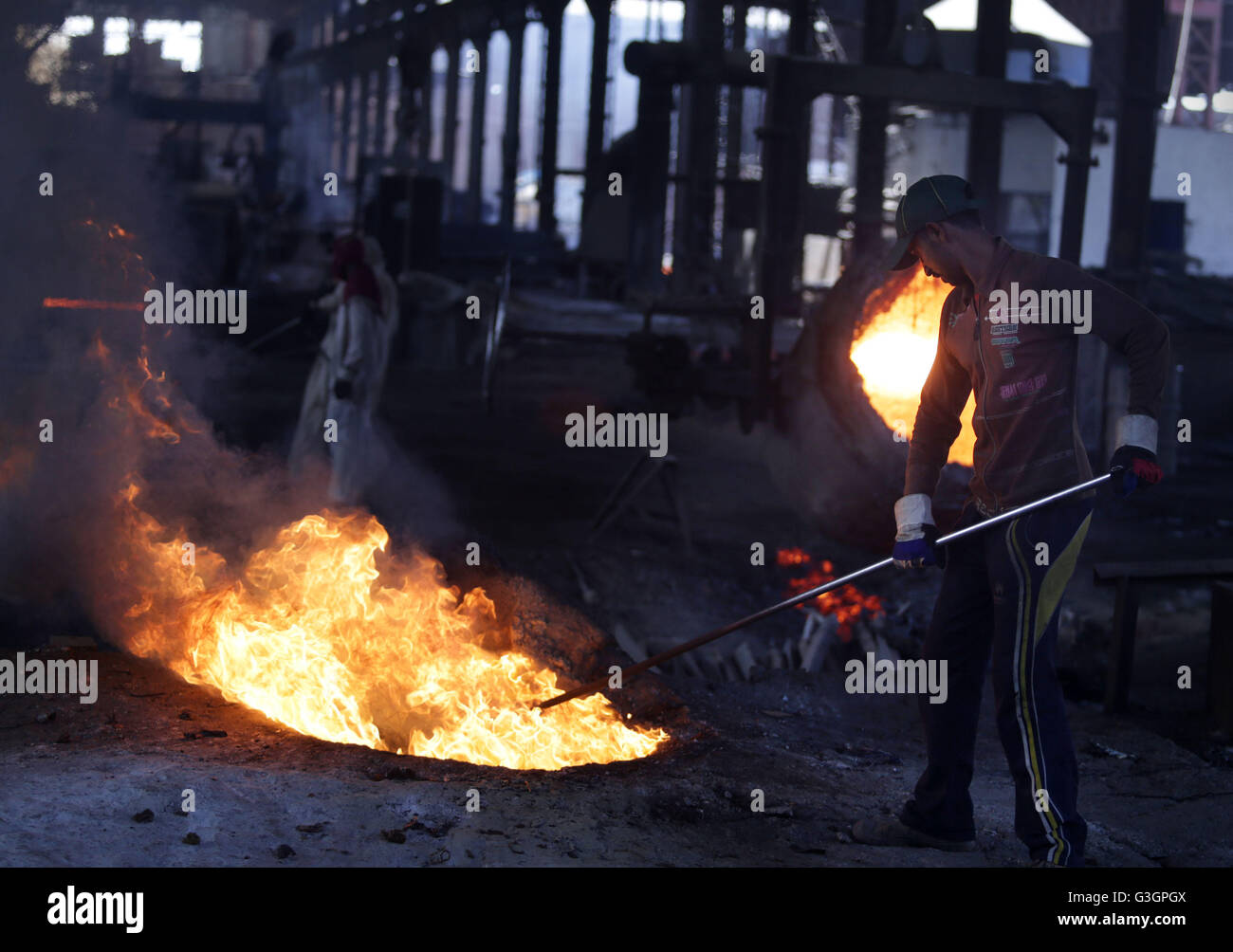 Pakistani blacksmiths work at an iron molding factory in an industrial ...