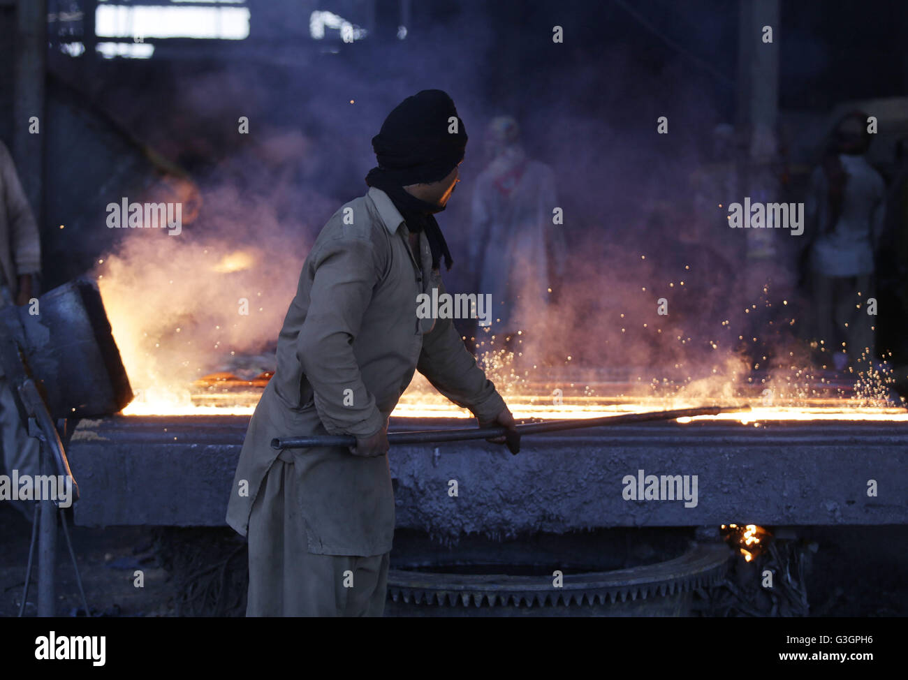 Pakistani blacksmiths work at an iron molding factory in an industrial ...