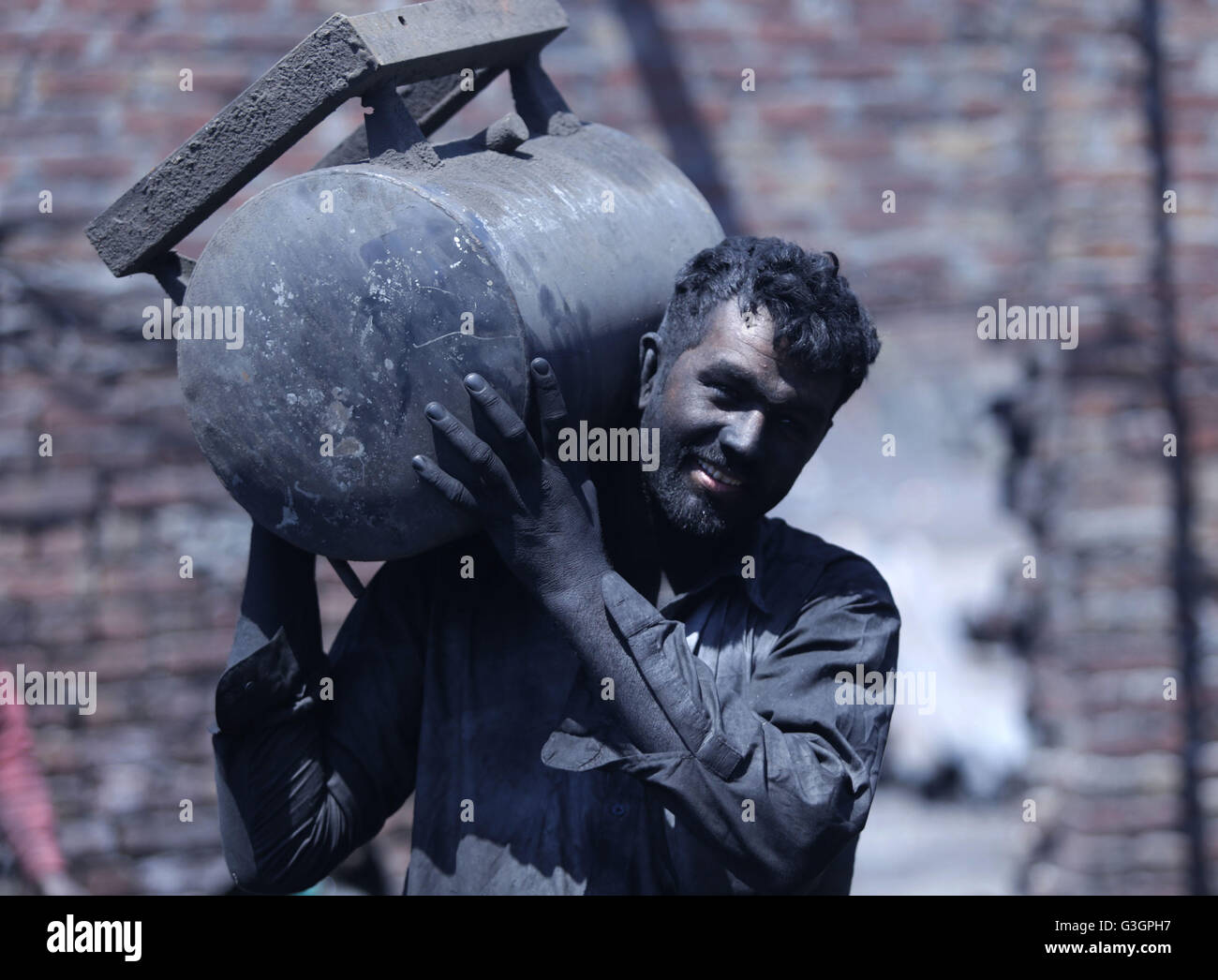 Pakistani blacksmiths work at an iron molding factory in an industrial ...