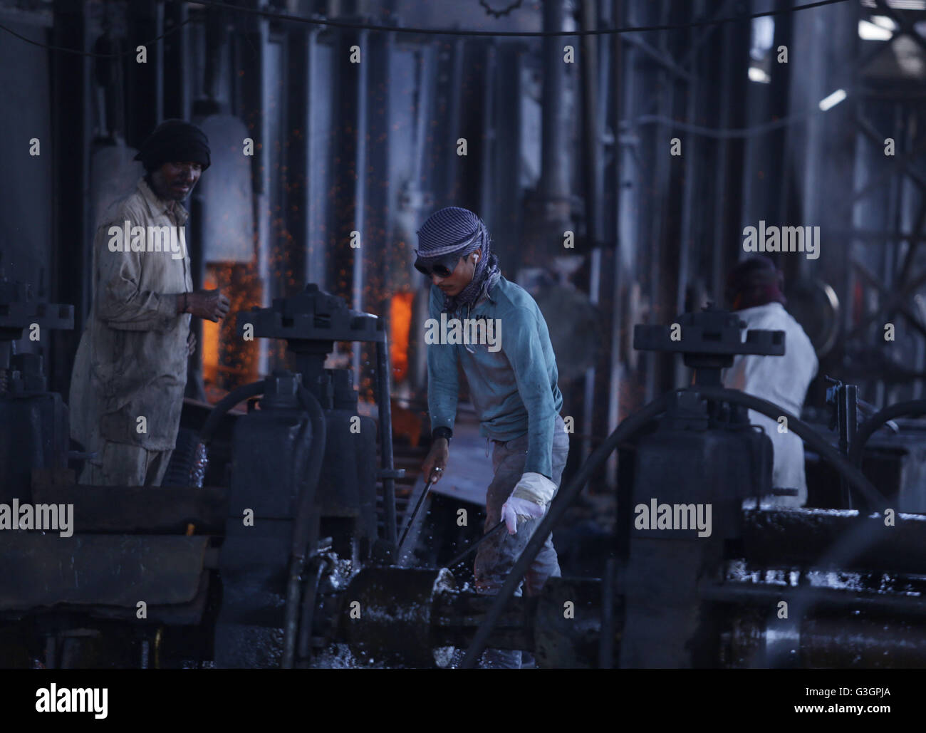 Pakistani blacksmiths work at an iron molding factory in an industrial ...
