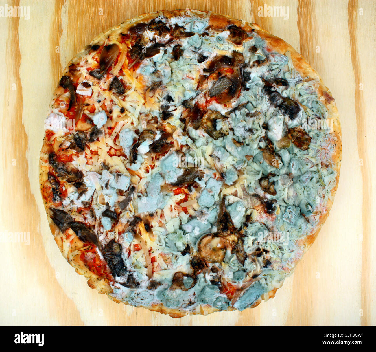 Old moldy pizza on a wooden table. Food poisoning Stock Photo - Alamy