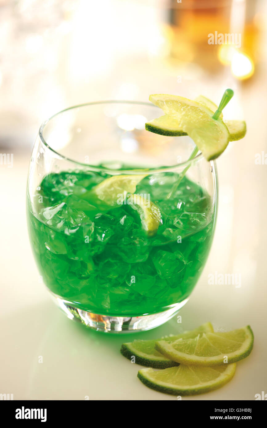 Green cocktail with crushed ice and slices of lime in a glass Stock ...