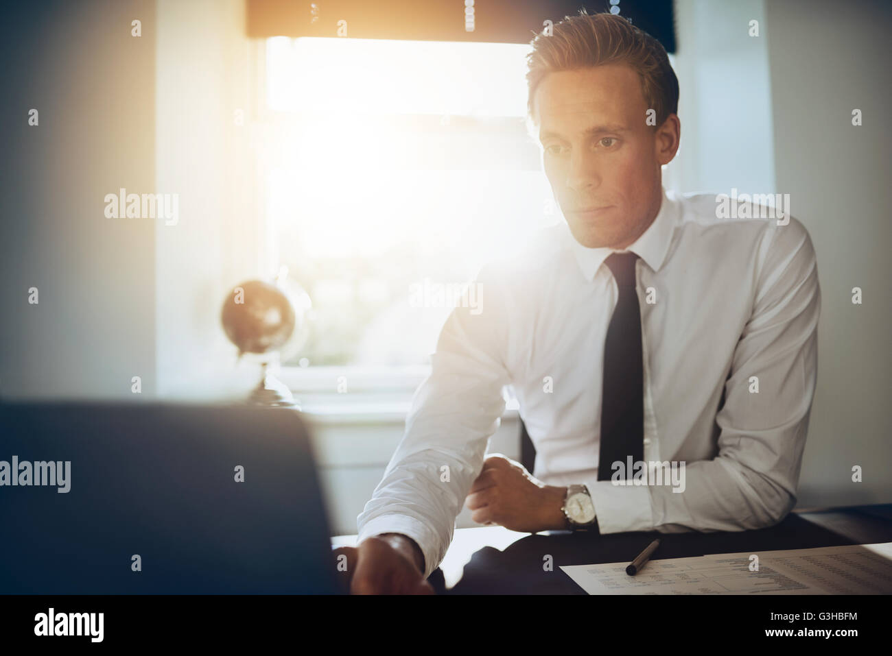 white male executive business man working at his laptop sitting at his ...