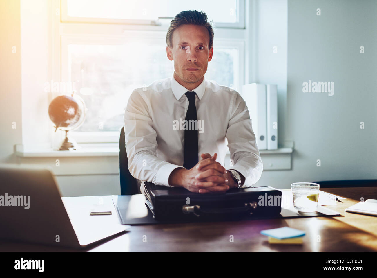 Executive business man at his desk looking with authority at the camera ...