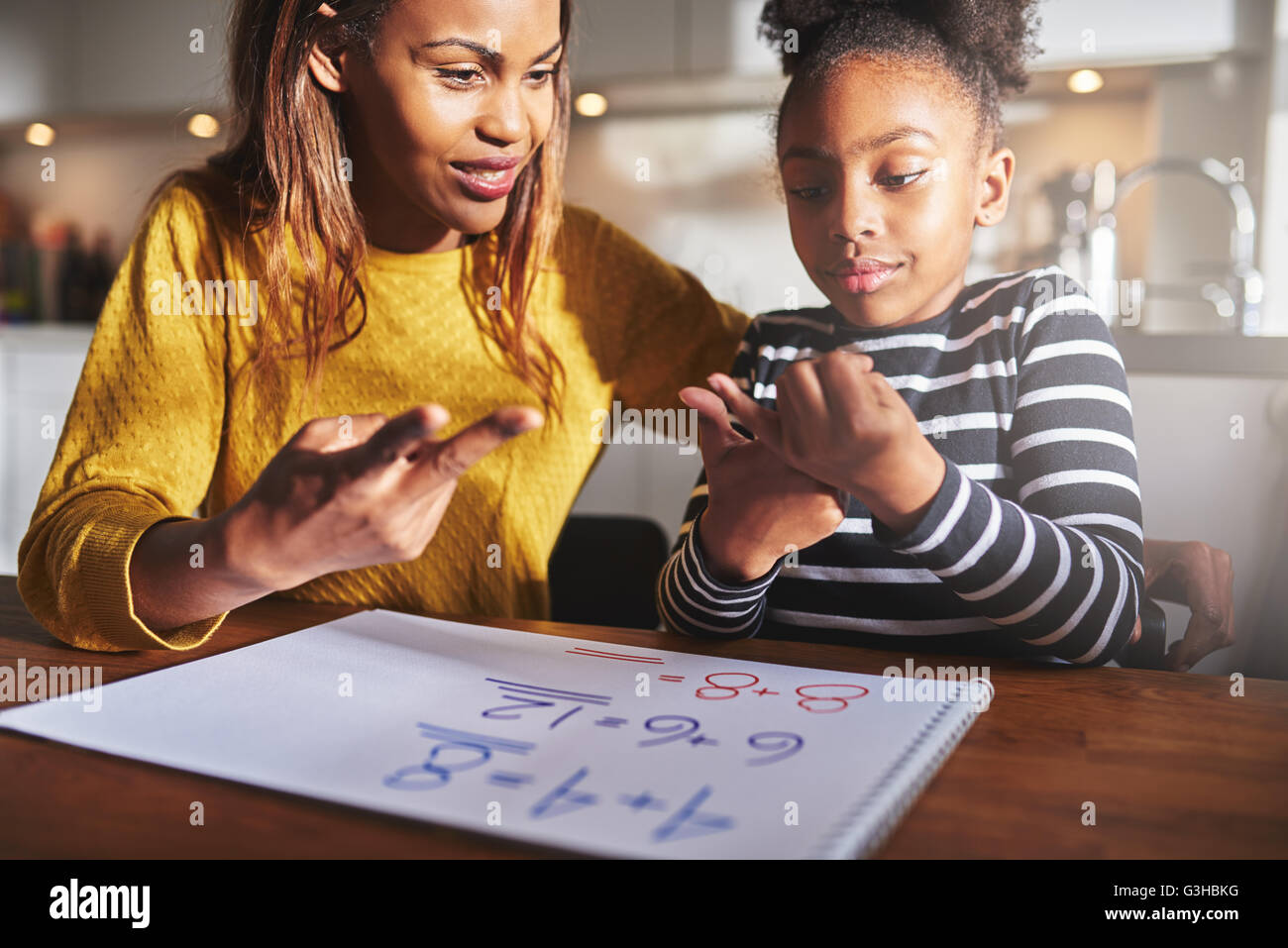 Excited child learning to calculate at home, black mother and daughter ...