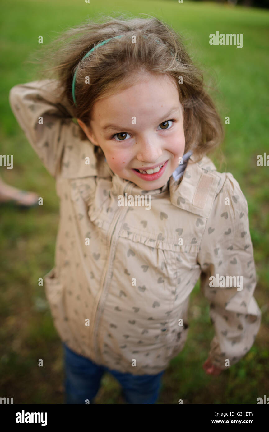The girl of 7-8 years with a smile looks in a camera. She has fair wild ...