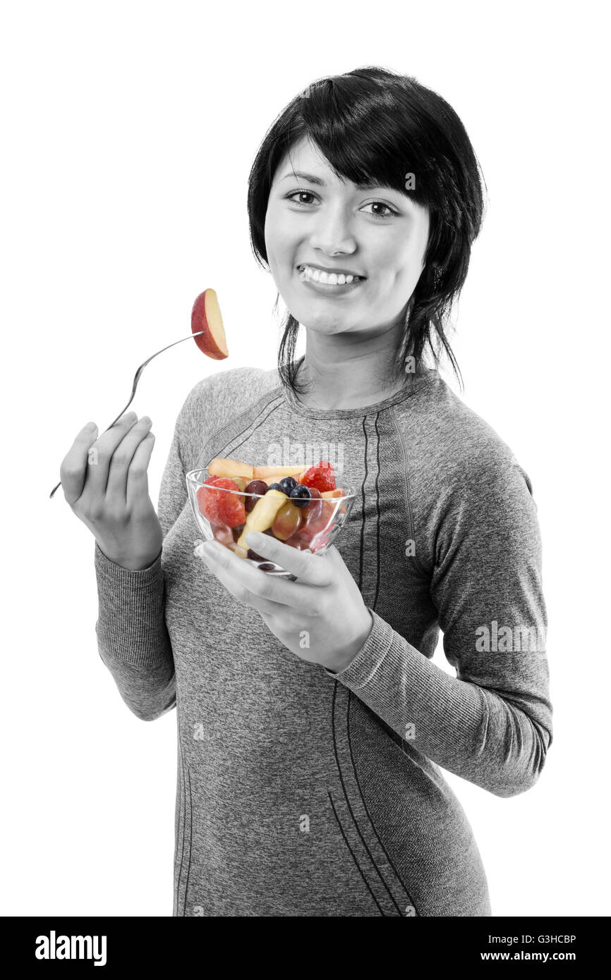 studio shot of a pretty, young, slim, fitness model eating a healthy ...