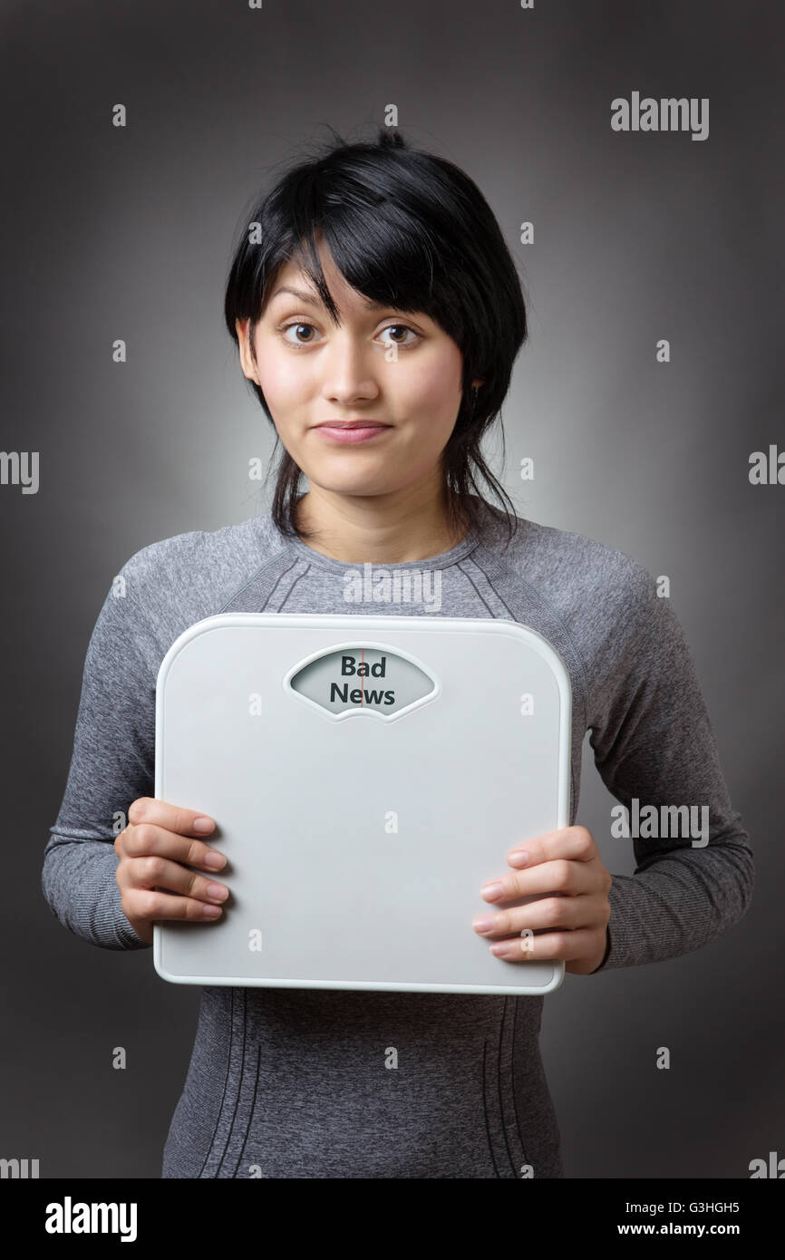 woman holding scales looking worried with the word bad news written on ...