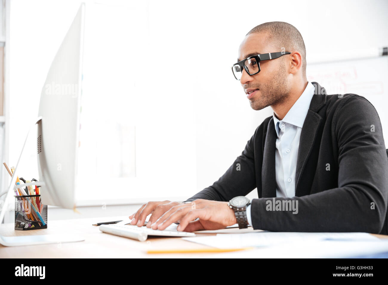 Smart young businessman looking at the computer in office Stock Photo ...