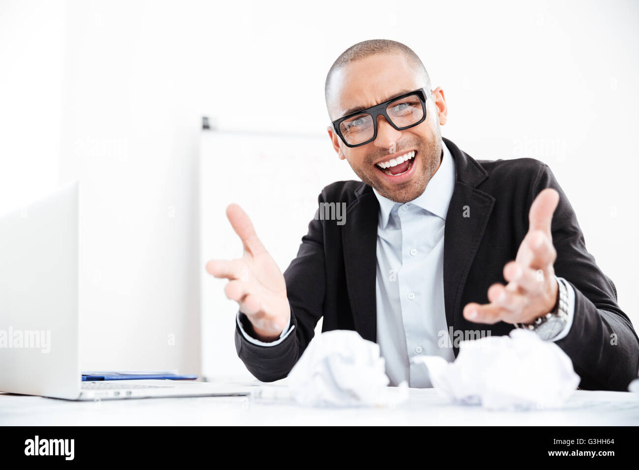 Angry nervous businessman working at office desk overloaded with ...