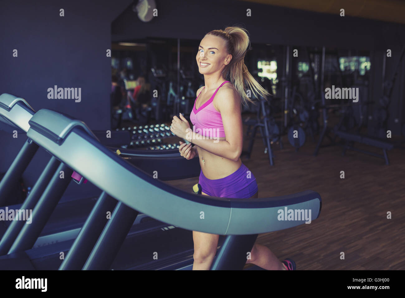 Fitness girl running on treadmill Stock Photo - Alamy