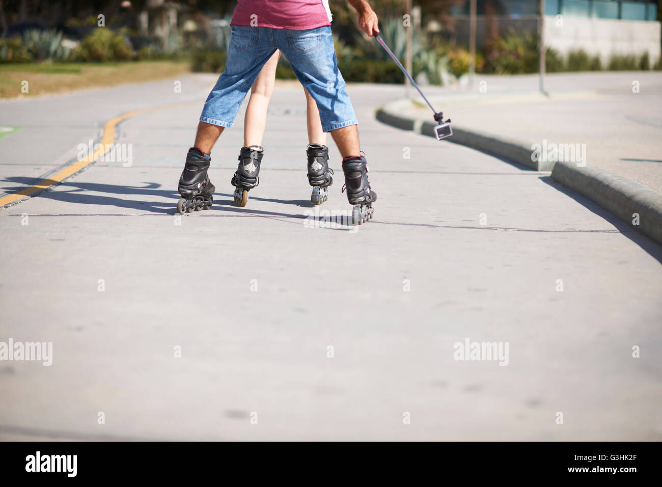 Couple rollerblading outdoors, rear view, low section Stock Photo - Alamy