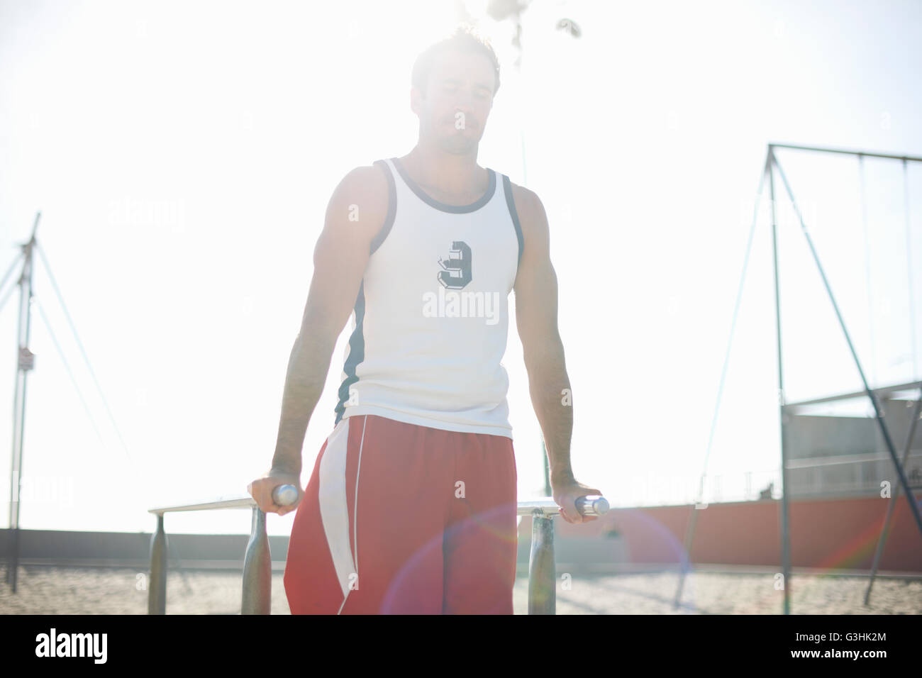 Mid adult man exercising on beach, using gymnastics parallel bars Stock ...