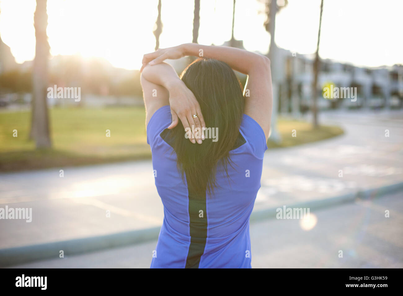 Rear view of woman hand behind head stretching Stock Photo - Alamy
