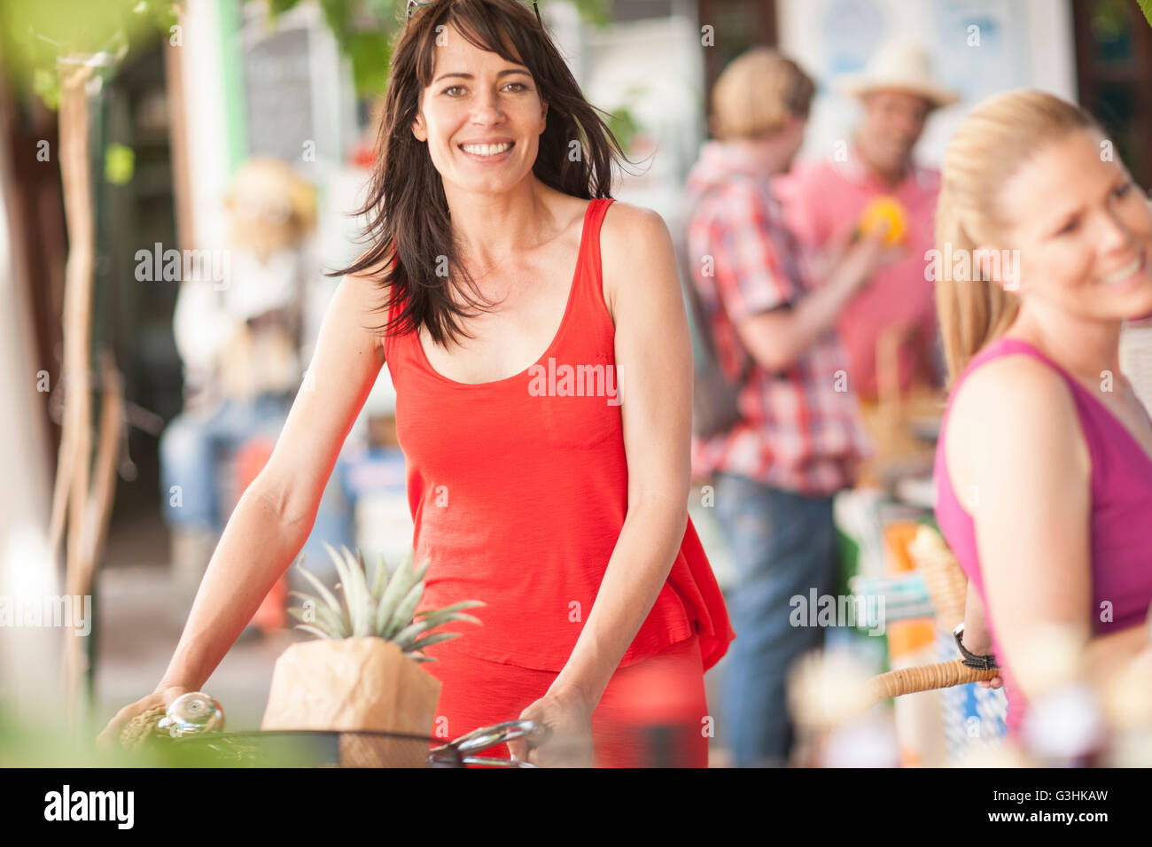 Woman riding bicycle in market Stock Photo - Alamy