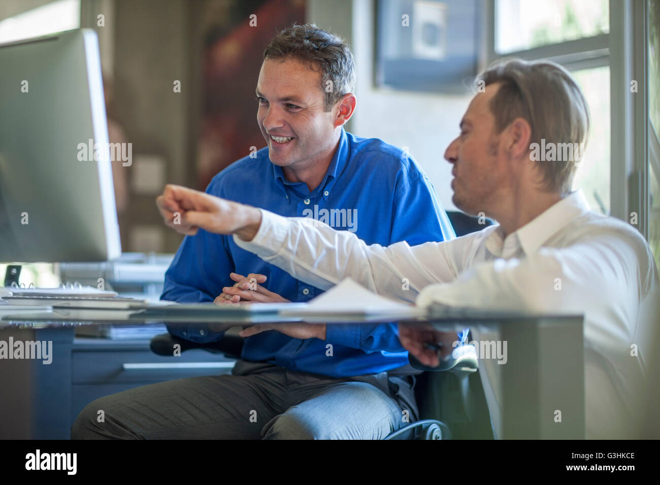 Male designer pointing at desktop computer in design office Stock Photo ...