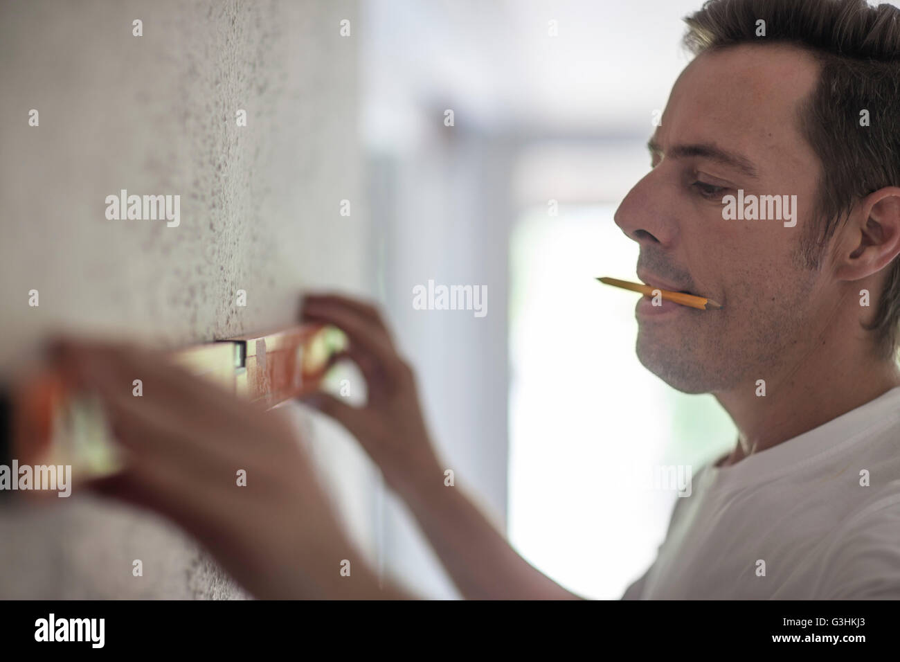 Builder measuring wall Stock Photo - Alamy