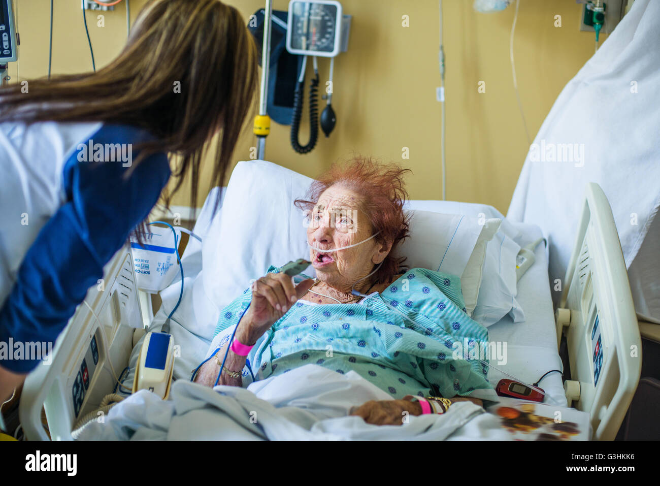 Patient on hospital bed talking to visitor Stock Photo - Alamy