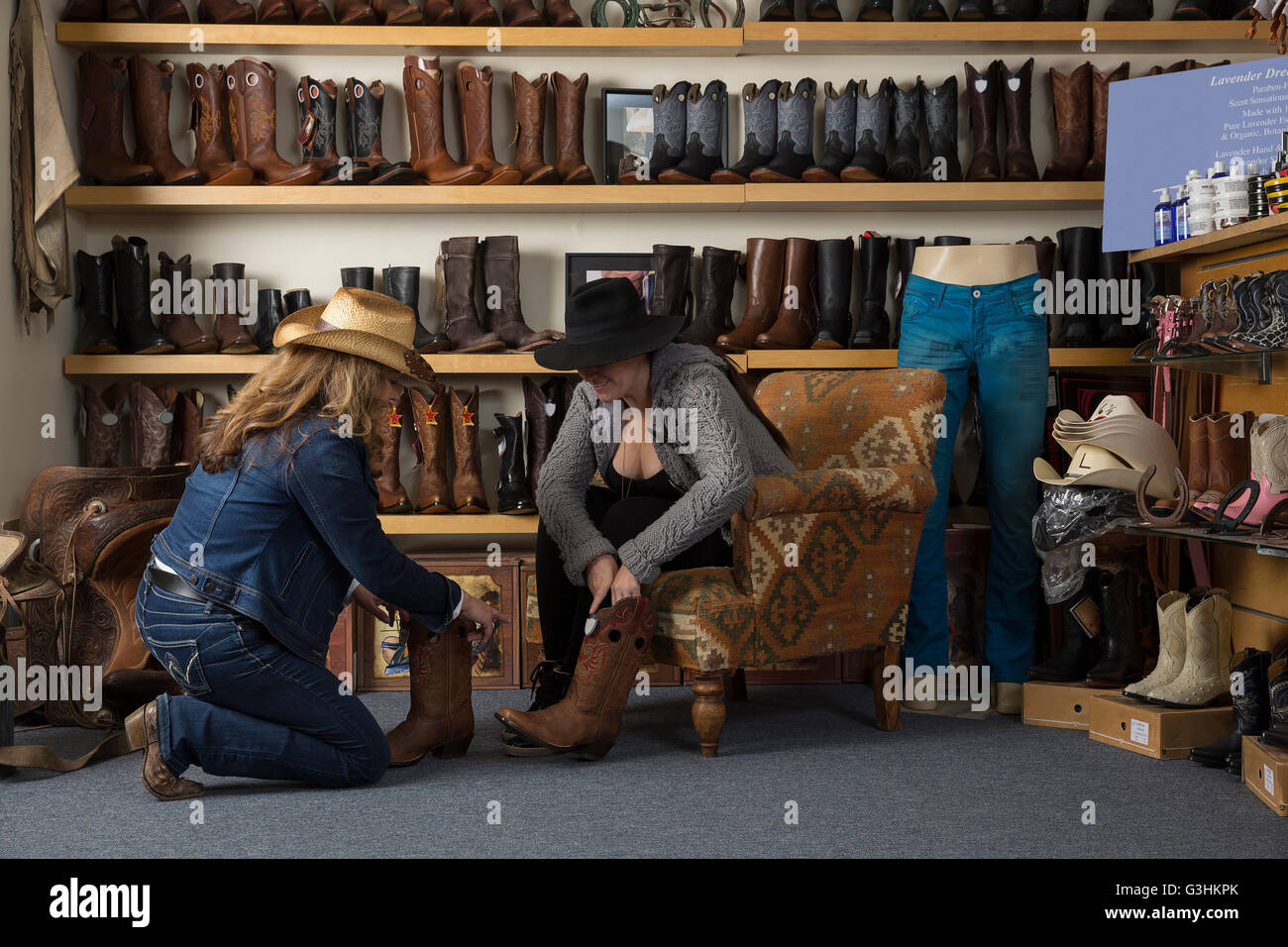 Shop assistant helping customer with boots Stock Photo - Alamy