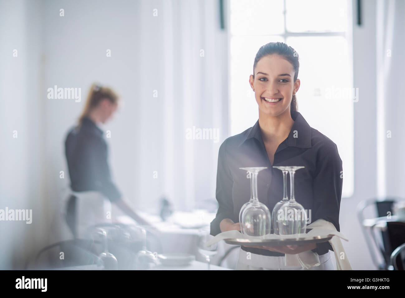 Waitresses setting table in restaurant Stock Photo - Alamy