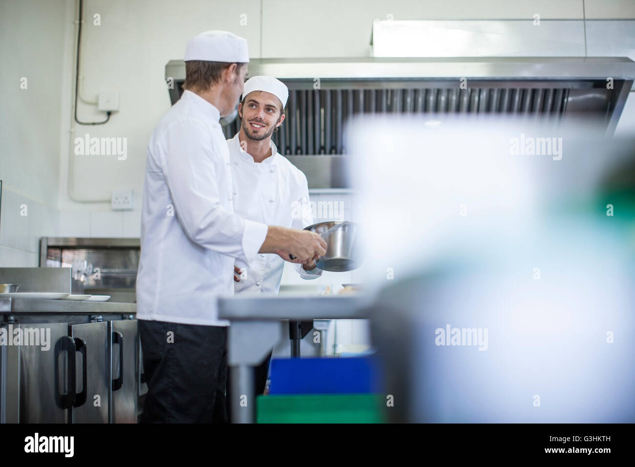 Chefs chatting and preparing food in kitchen Stock Photo - Alamy