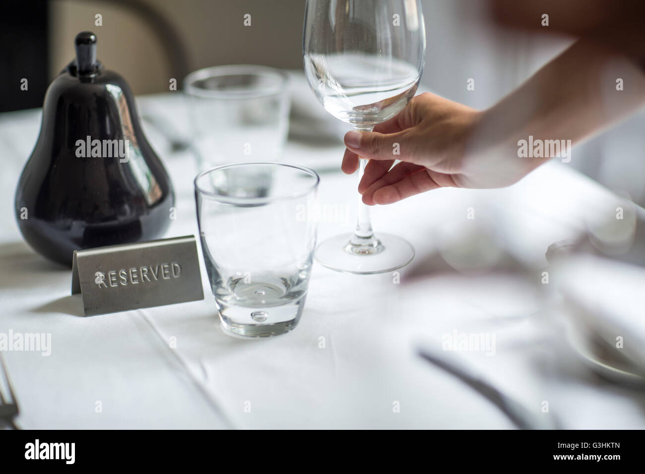 Waitress setting table in restaurant Stock Photo - Alamy