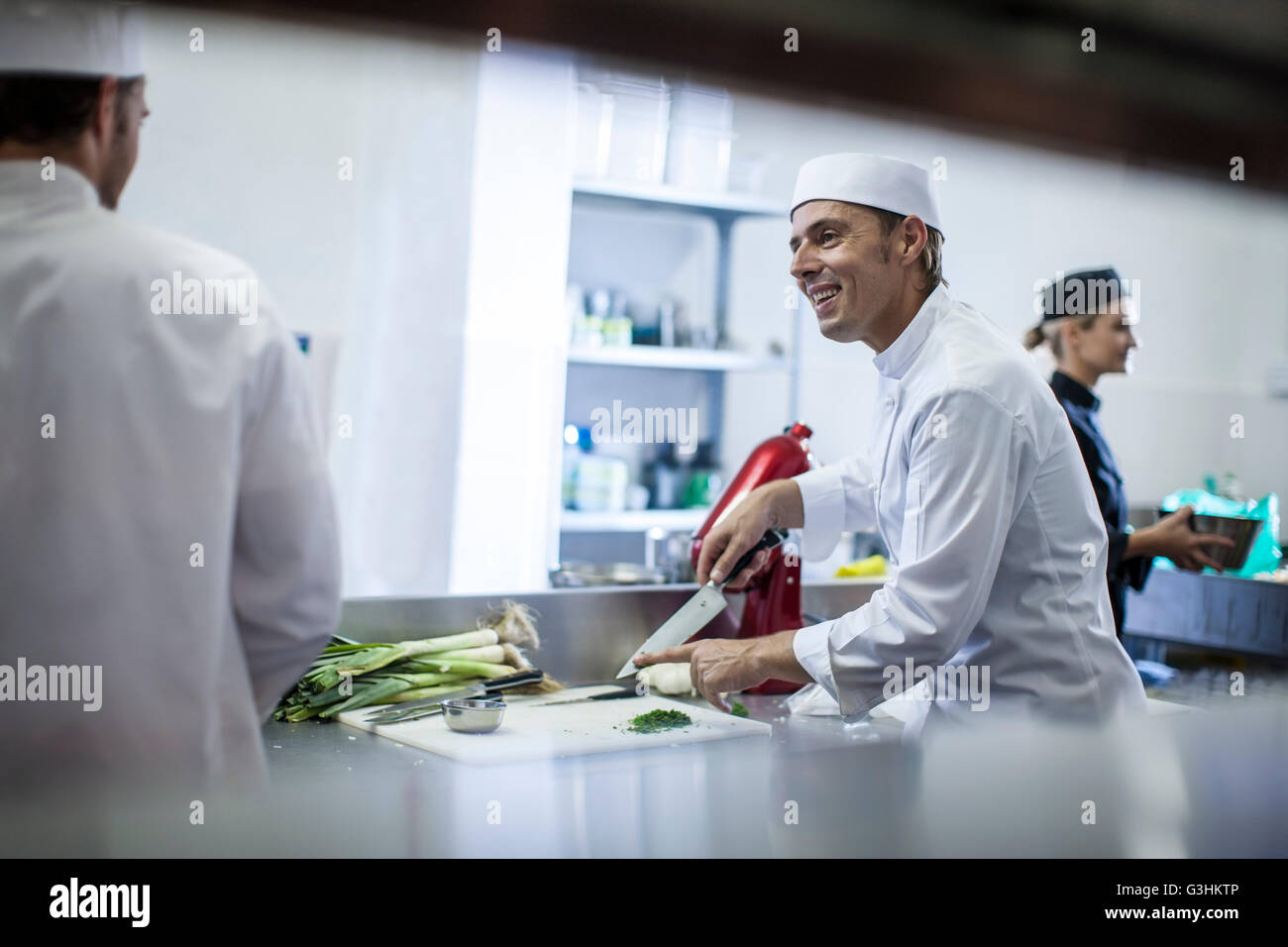 Chefs chatting and preparing food in kitchen Stock Photo - Alamy