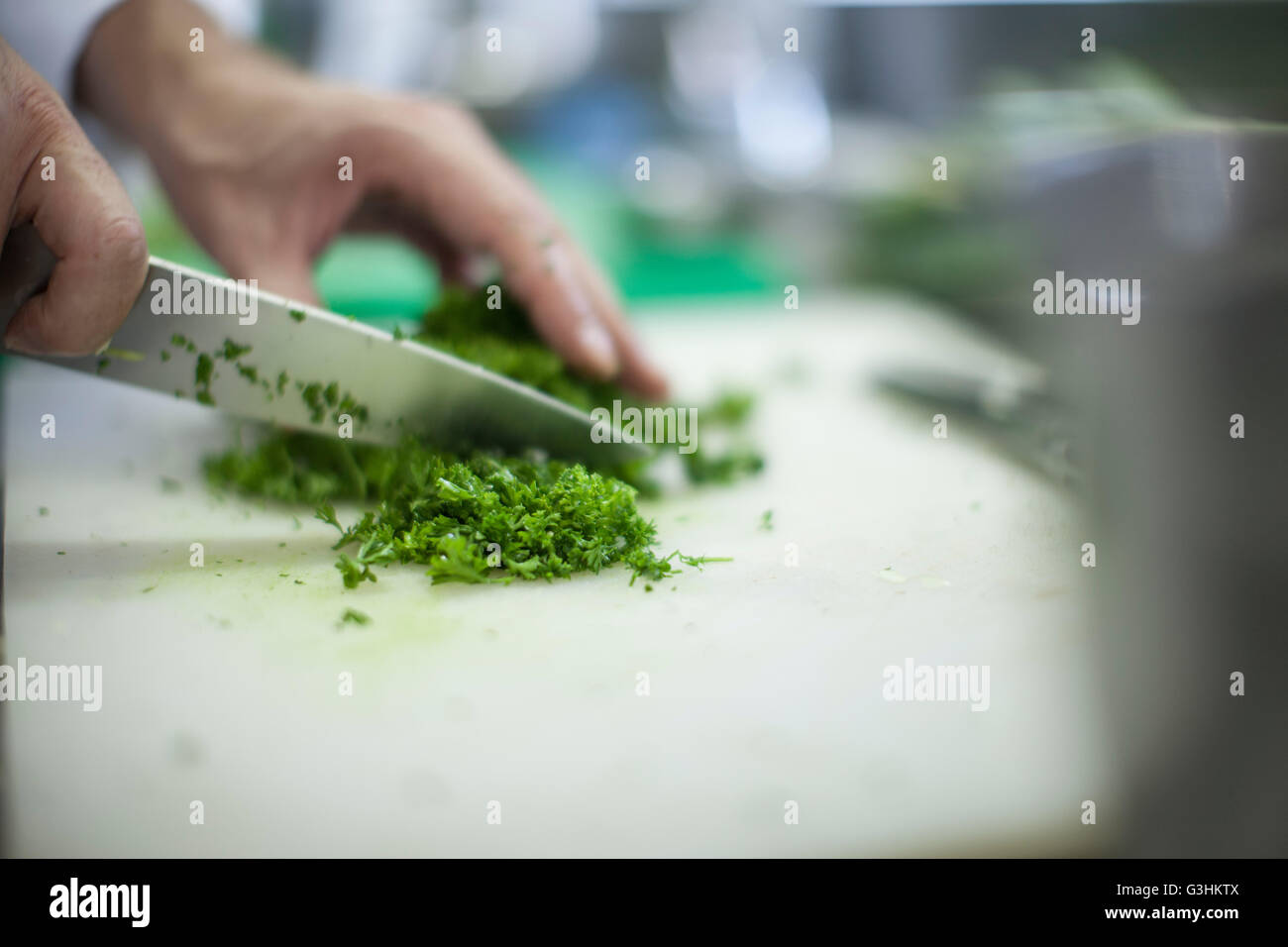 Chef chopping fresh herbs on table Stock Photo - Alamy