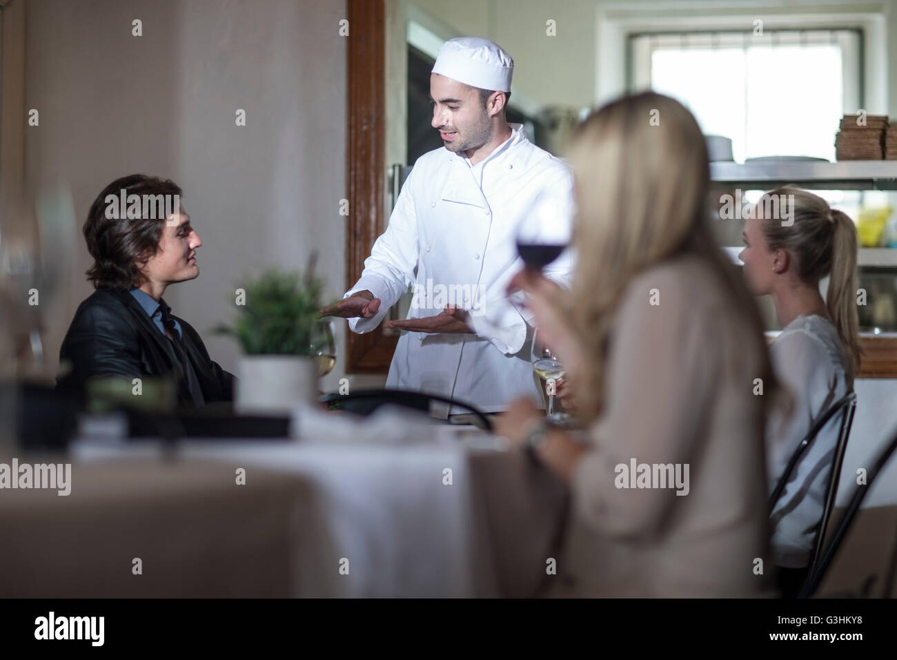 Chef chatting with customers in restaurant Stock Photo - Alamy