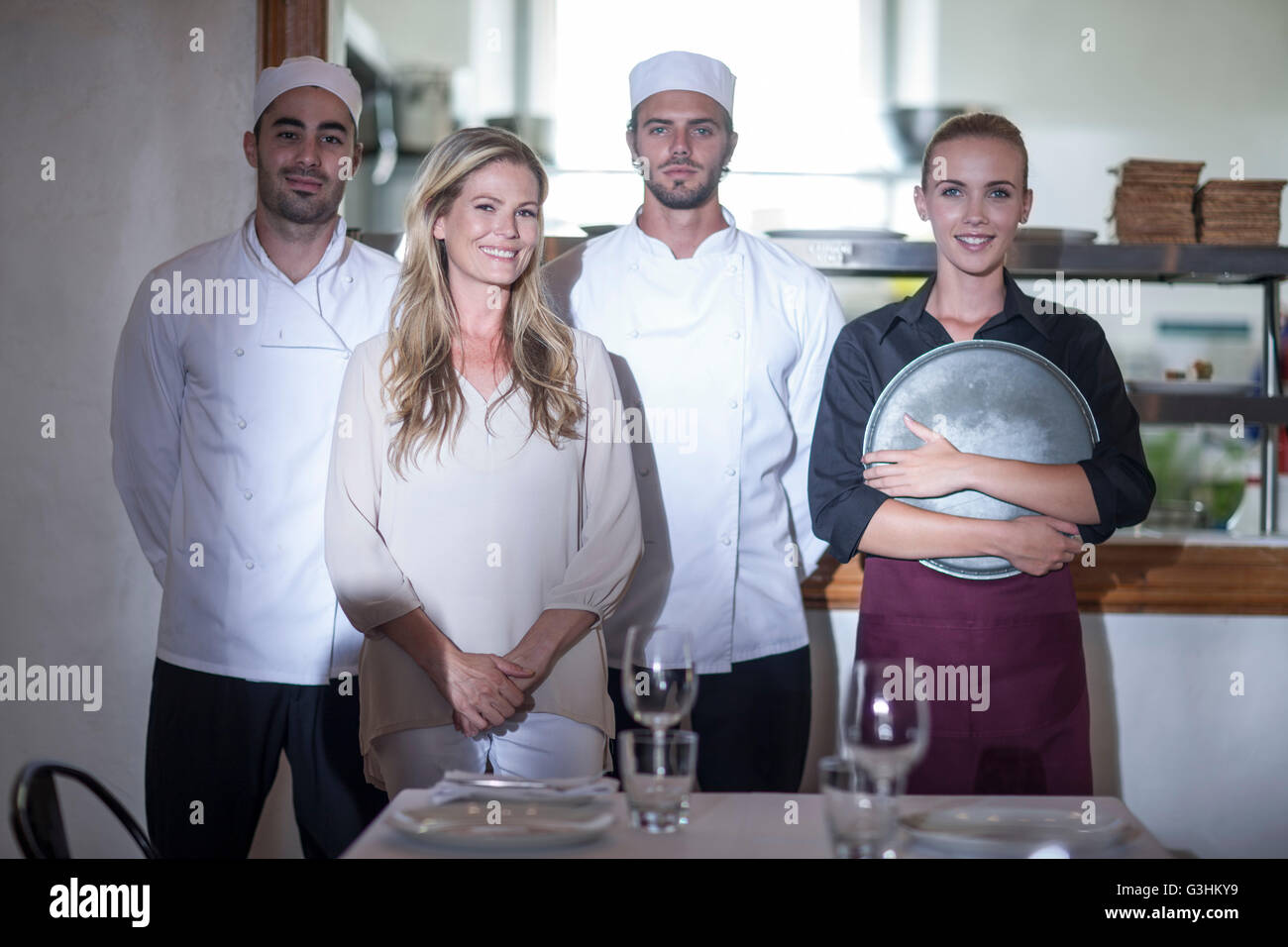 Chefs and waitresses in restaurant Stock Photo - Alamy