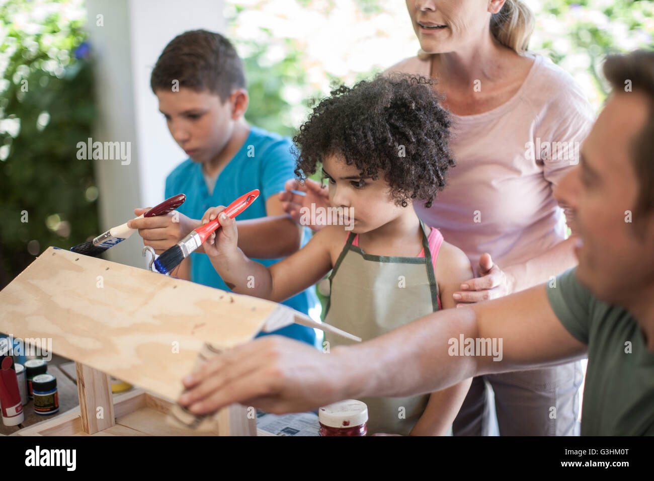 Family doing crafts together, making birdhouse Stock Photo - Alamy