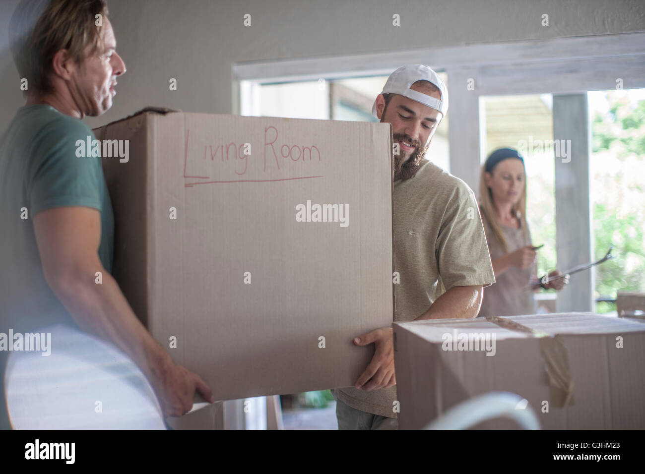 Moving house: two men carrying cardboard box Stock Photo - Alamy