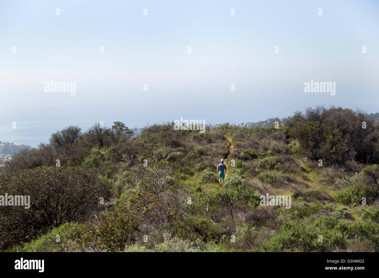 Man in the distance on mountain peak Stock Photo - Alamy
