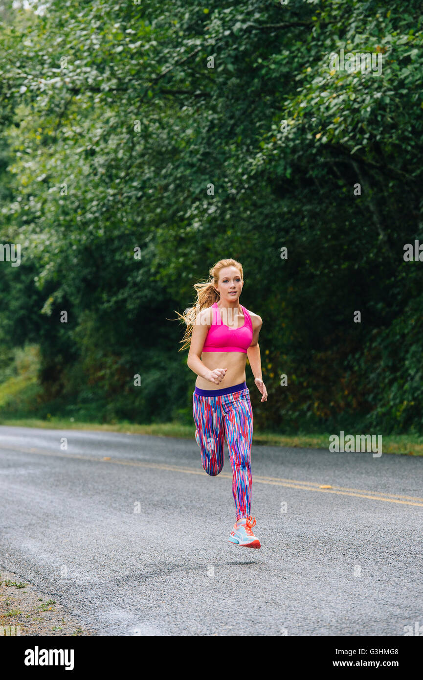Teenage girl running up rural road Stock Photo - Alamy