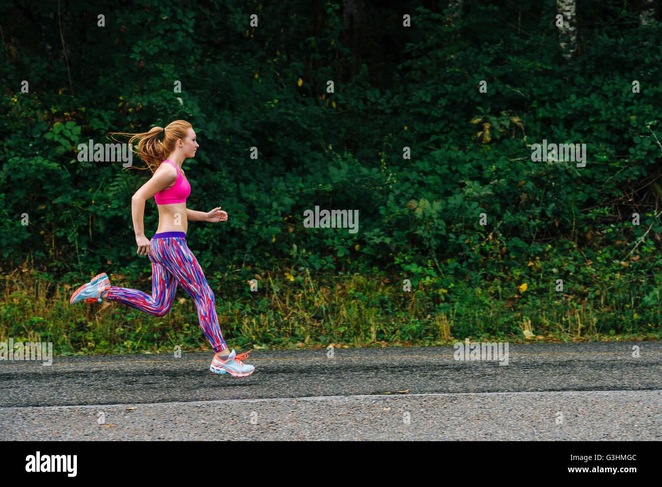 Teenage girl running along rural road Stock Photo - Alamy