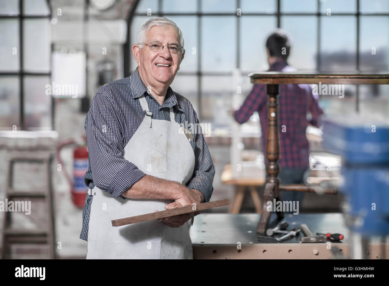Portrait of senior craftsman in antique restoration workshop Stock ...