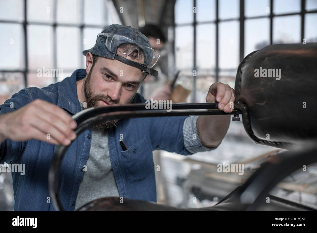 Young craftsman inspecting chair in antique restoration workshop Stock ...