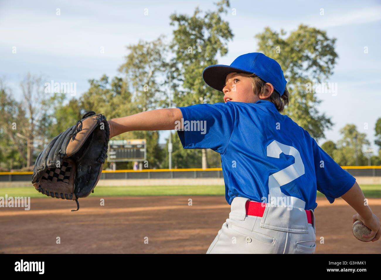 Boy throwing ball at practise on baseball field Stock Photo - Alamy