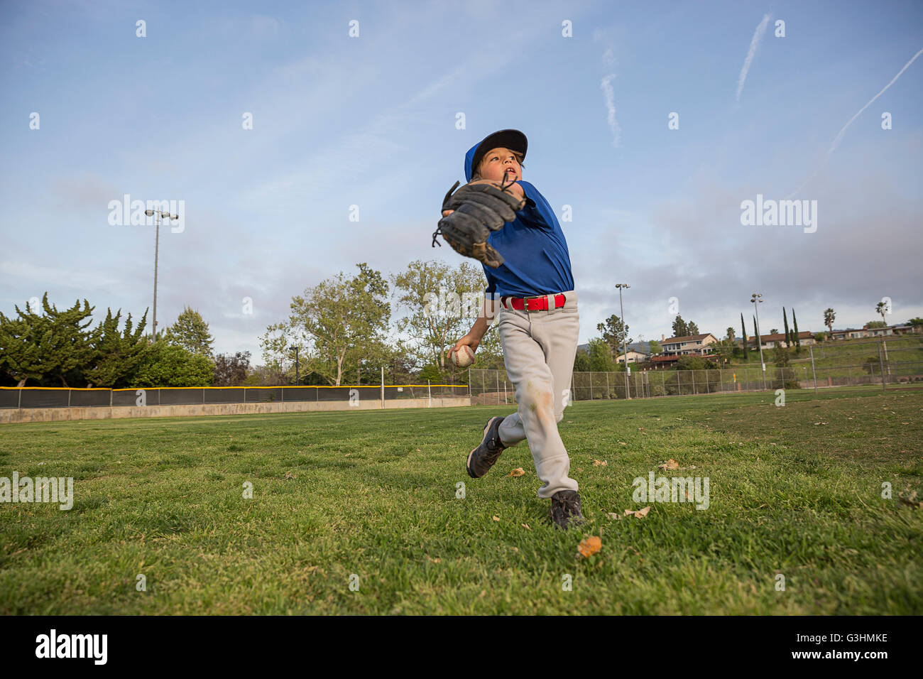 Boy throwing ball at practise on baseball field Stock Photo - Alamy