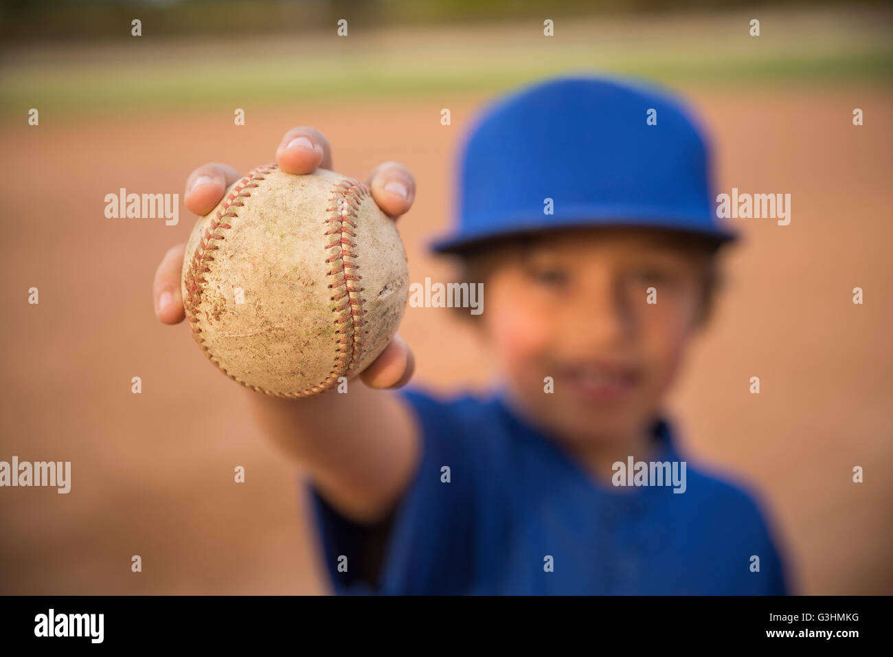 Blurred portrait of boy holding up ball at baseball practise Stock ...