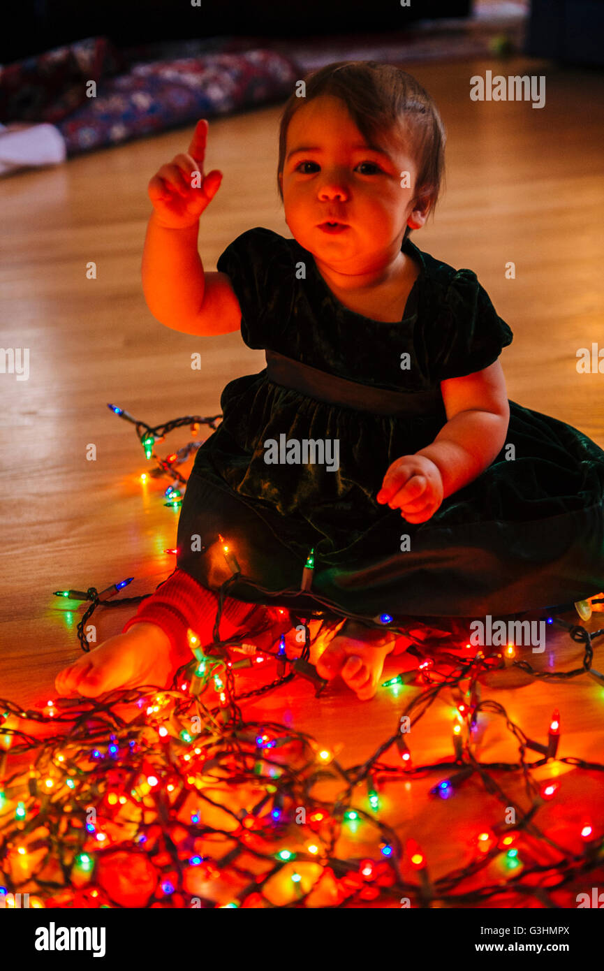 Female toddler raising hand whilst playing with multi-coloured ...