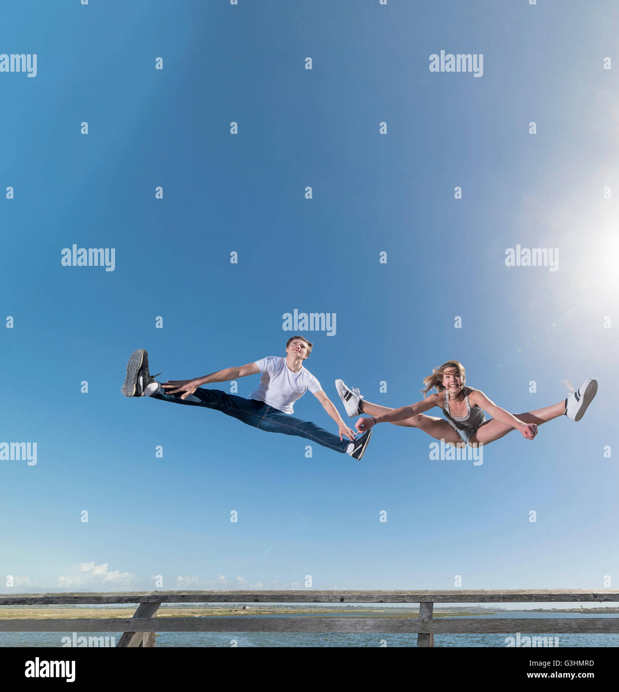 Couple doing splits in mid air Stock Photo - Alamy