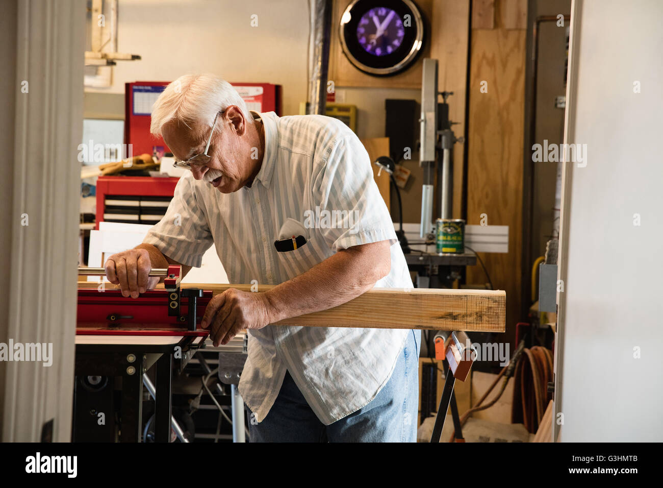 Senior man placing woodblock on carpentry equipment workshop Stock ...